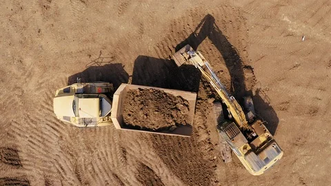 Excavator loading soil onto an Articulat... | Stock Video | Pond5