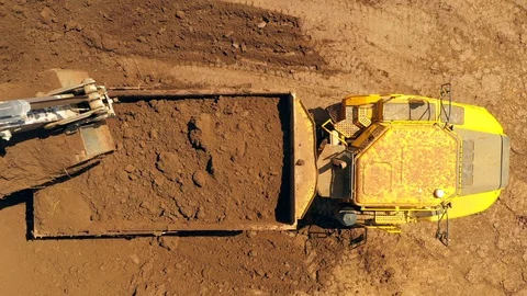 Excavator loading soil onto an Articulat... | Stock Video | Pond5