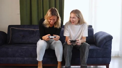 Excited gamer girls sitting on a couch a... | Stock Video | Pond5
