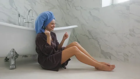 Excited young woman wearing robe sitting... | Stock Video | Pond5