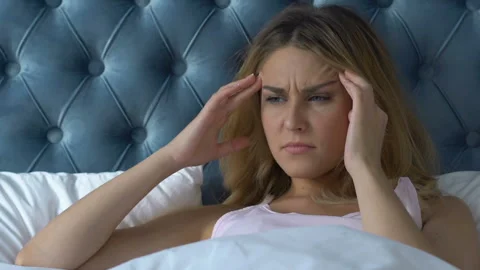 Exhausted woman lying in bed and rubbing... | Stock Video | Pond5