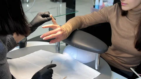 Experienced beautician looks at lady fin... | Stock Video | Pond5
