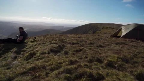 An explorer lying down to rest on a moun... | Stock Video | Pond5