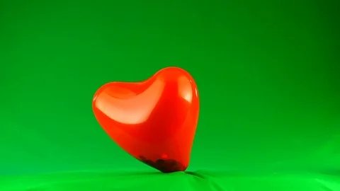 explosion of a red balloon on a green ba... | Stock Video | Pond5