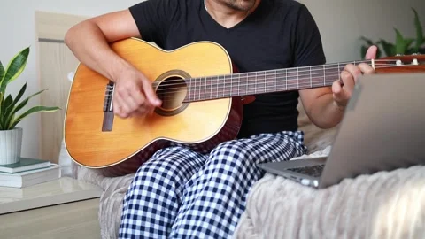 Faceless man playing guitar on bed next ... | Stock Video | Pond5