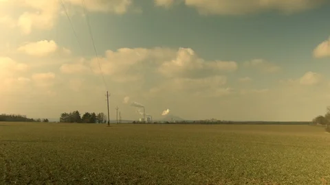 Factory behind the field, smoking chimne... | Stock Video | Pond5