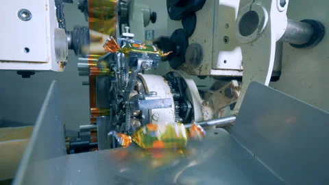 Factory machine is wrapping chocolate sw... | Stock Video | Pond5