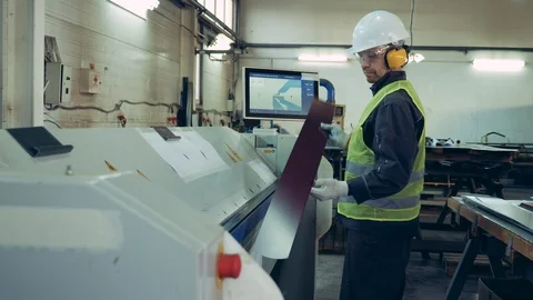 Factory worker is loading a metal sheet ... | Stock Video | Pond5