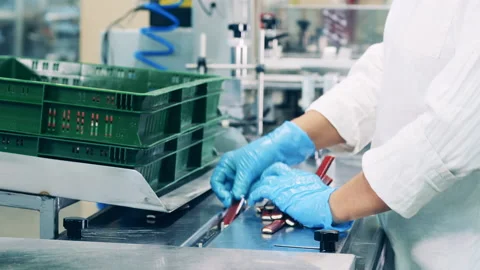 Factory worker is putting sweets into th... | Stock Video | Pond5