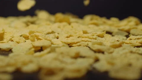 Falling corn flakes on a black backgroun... | Stock Video | Pond5