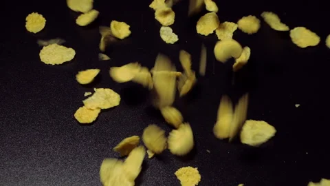 Falling corn flakes on a black backgroun... | Stock Video | Pond5