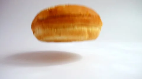 Falling hamburger bun on a white backgro... | Stock Video | Pond5