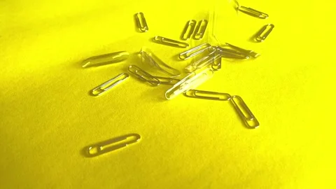 Falling metal paper clips on the table. ... | Stock Video | Pond5