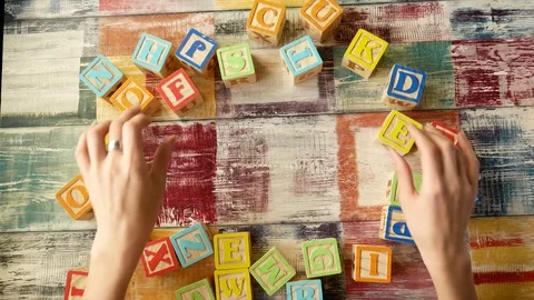 Falling toy bricks make up different wor... | Stock Video | Pond5