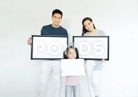 Family showing and holding empty white picture frame over white ...
