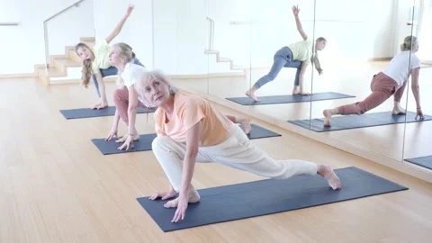 Family standing in tree pose during yoga... | Stock Video | Pond5