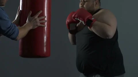 Fat man heavily striking punching bag, p... | Stock Video | Pond5