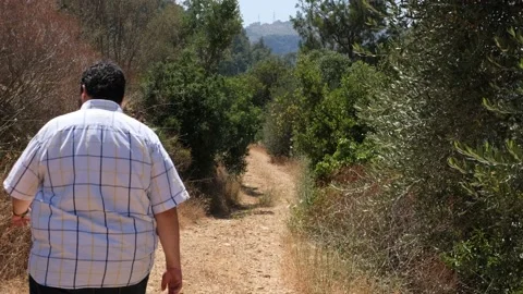 Fat man walking in the nature | Stock Video | Pond5