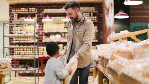 Father and son buying bread in grocery s... | Stock Video | Pond5