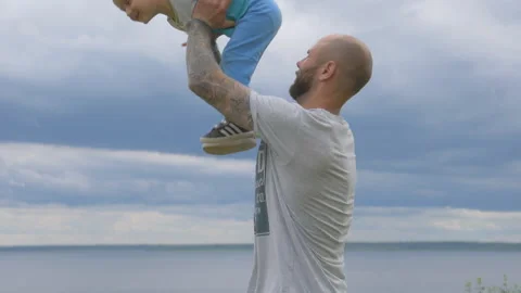 Father raising high his cute son up with... | Stock Video | Pond5