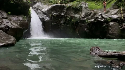 Fearless young man jumps into the waterf... | Stock Video | Pond5
