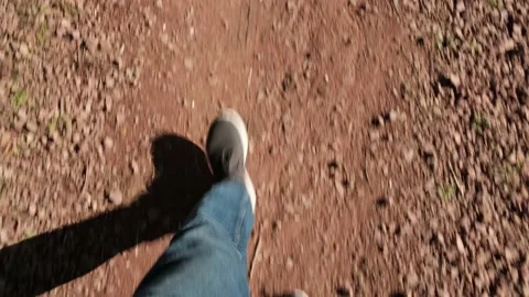 Feet walk on a dirt road. First person v... | Stock Video | Pond5