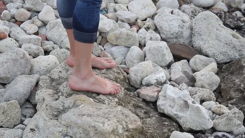 Female bare feet step on stones on the s... | Stock Video | Pond5