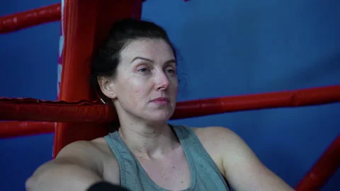 Female boxer covered with sweat relaxing... | Stock Video | Pond5