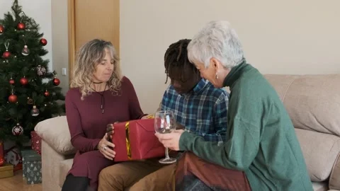 Female couple giving a christmas gift to... | Stock Video | Pond5