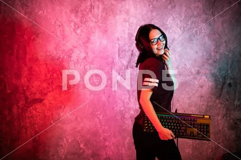 Female esports gamer posing with a gaming gear in neon light. Streamer ...