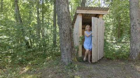 Female farmer going to outhouse arborloo... | Stock Video | Pond5
