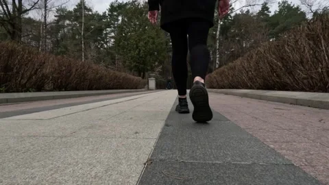 Female feet in black sneakers walk along... | Stock Video | Pond5