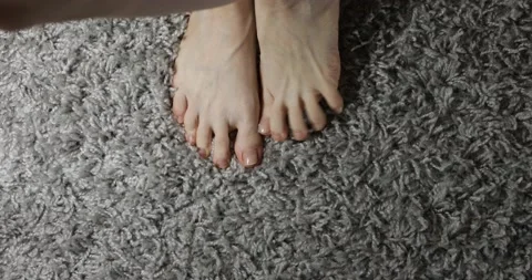 female feet on gray carpet, top view | Stock Video | Pond5