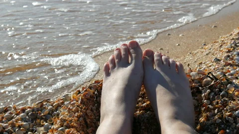 Female feet, toes on a seashell beach, s... | Stock Video | Pond5