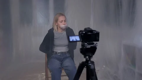 A female hostage sits on a chair with he... | Stock Video | Pond5