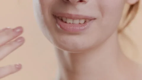 Female model strokes jawline, smiles wid... | Stock Video | Pond5