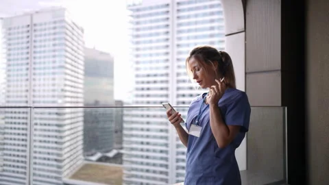 Female nurse smoking cigarette at balcon... | Stock Video | Pond5