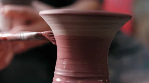 Female potter paints on rotating clay po... | Stock Video | Pond5