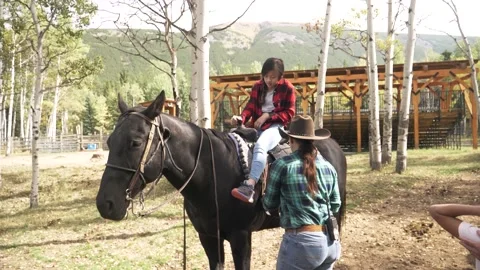 Female rancher helping girl prepare for ... | Stock Video | Pond5