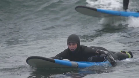 Female surfer lying on front on surfboar... | Stock Video | Pond5