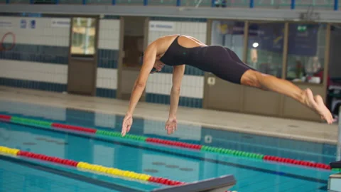 Female swimmer jumping into a pool from ... | Stock Video | Pond5