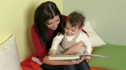 Female teacher reading book to little gi... | Stock Video | Pond5