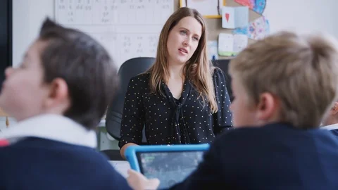Female teacher sitting at a table talkin... | Stock Video | Pond5