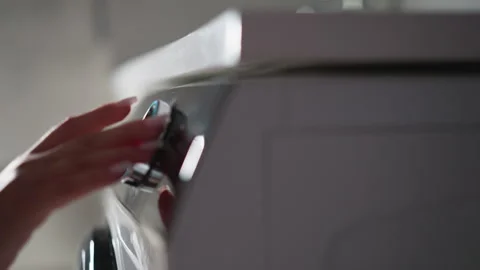 Female uses washing machine turning togg... | Stock Video | Pond5
