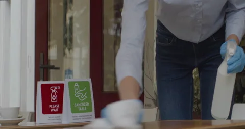 Female waiter sanitizing a table on a re... | Stock Video | Pond5