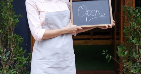 Female waiter standing with open sign bo... | Stock Video | Pond5