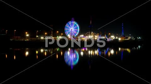 Photograph: Festival at beach area reflection in water during the ...