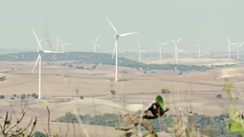 Few wind turbines spinning in a field on... | Stock Video | Pond5