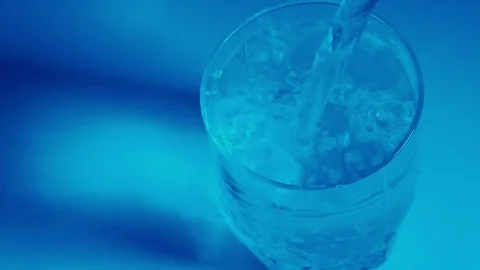 fill water in a transparent glass. blue ... | Stock Video | Pond5
