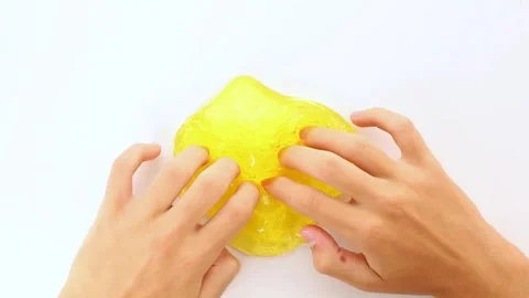 Fingers squeeze a yellow sticky mass on ... | Stock Video | Pond5